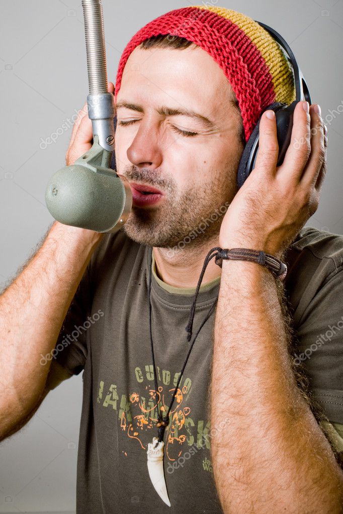 Young man singing in microphone Stock Photo by ©svyatoslavlipik 1274021