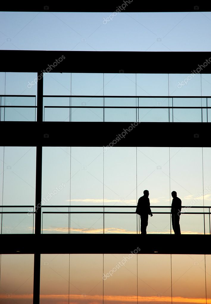 Two workers inside the building silhouette at sunset — Stock Photo ...